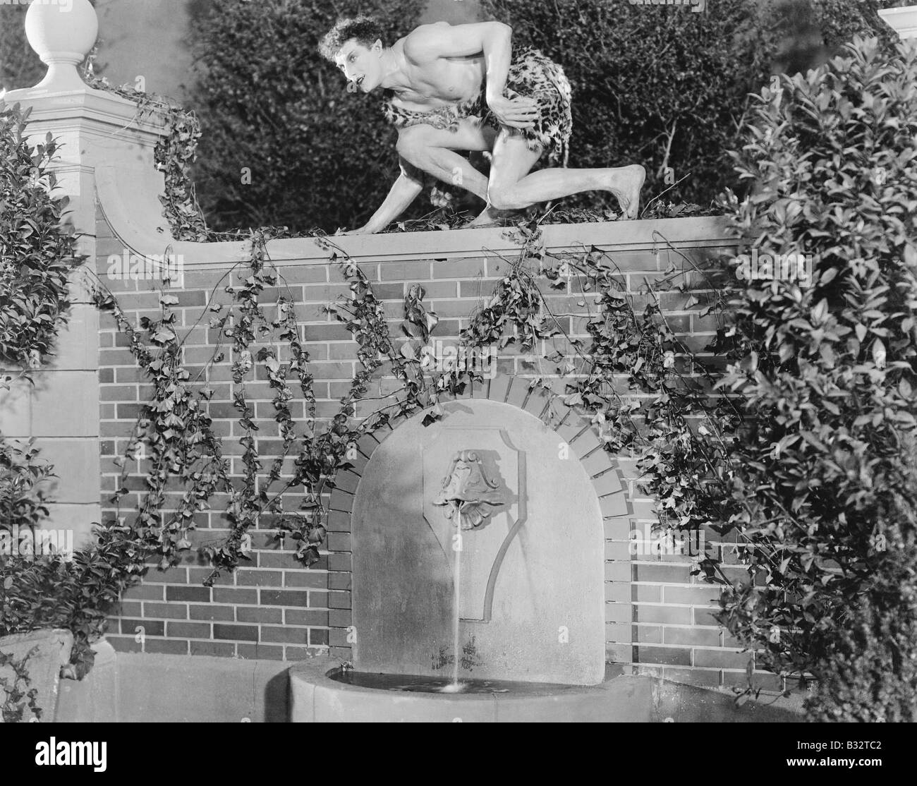 Profile of a young man crouching on a wall Stock Photo - Alamy