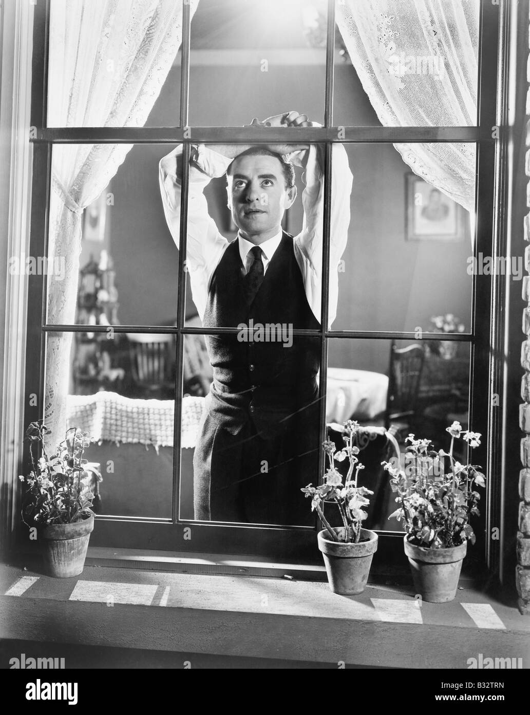Man leaning against a window while day dreaming Stock Photo - Alamy