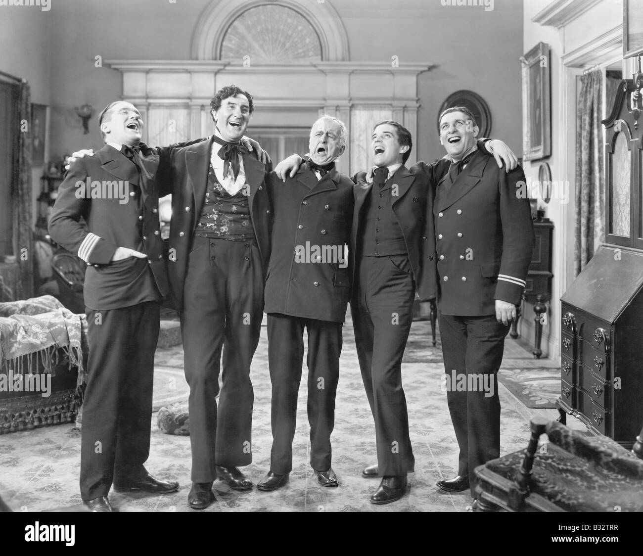 Five men standing together singing Stock Photo - Alamy