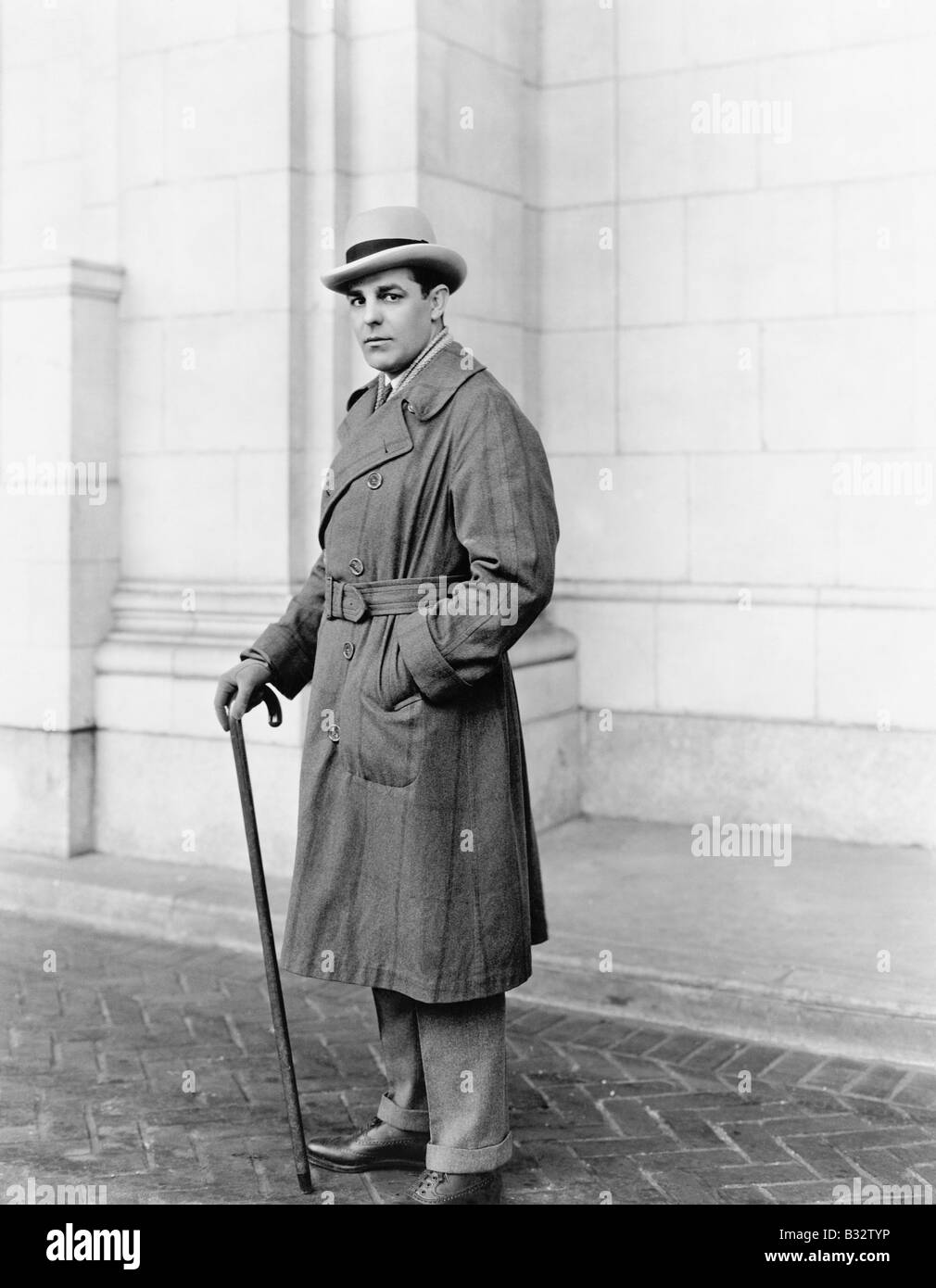 Elegantly dressed man standing in front of a building Stock Photo - Alamy