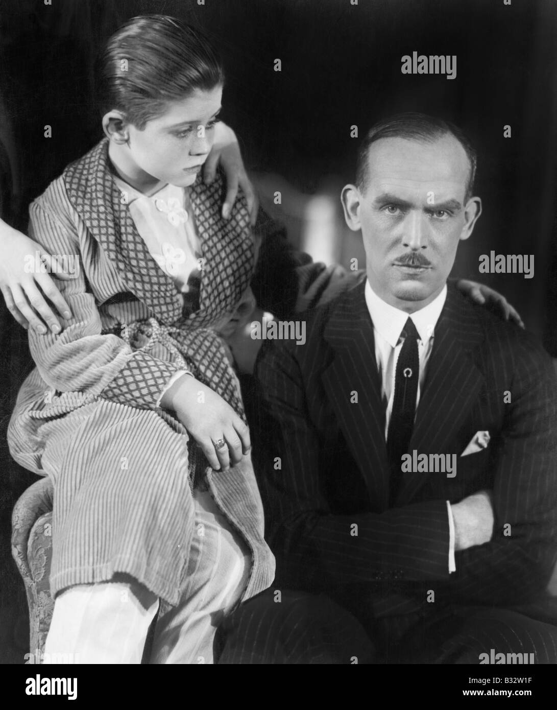 Young boy looking worried at his father Stock Photo - Alamy