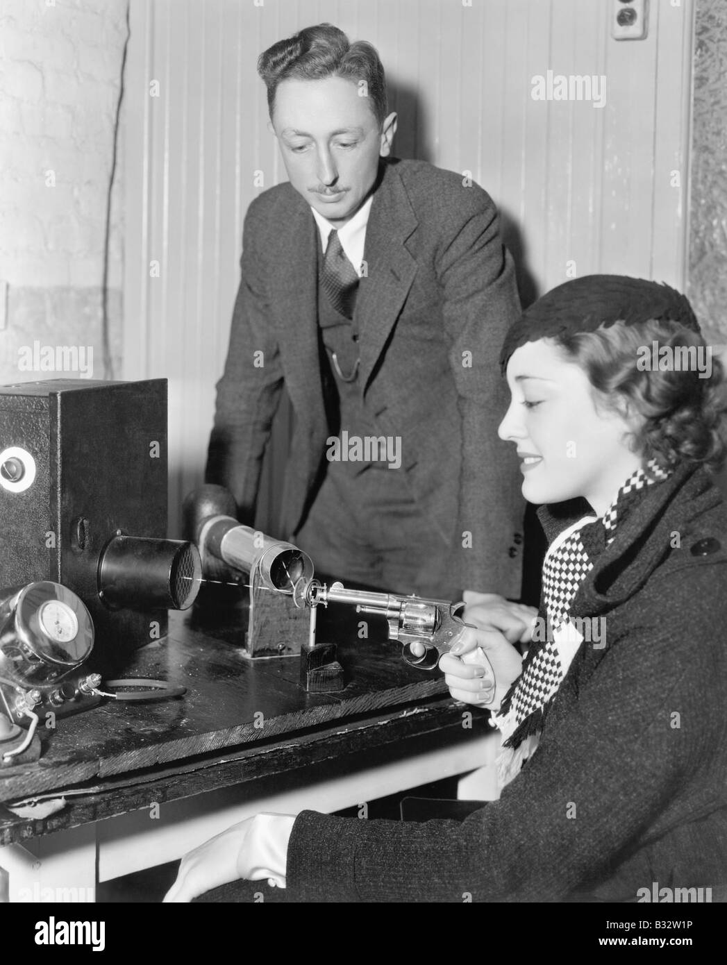 Woman holding a handgun shooting into a tremor machine Stock Photo - Alamy
