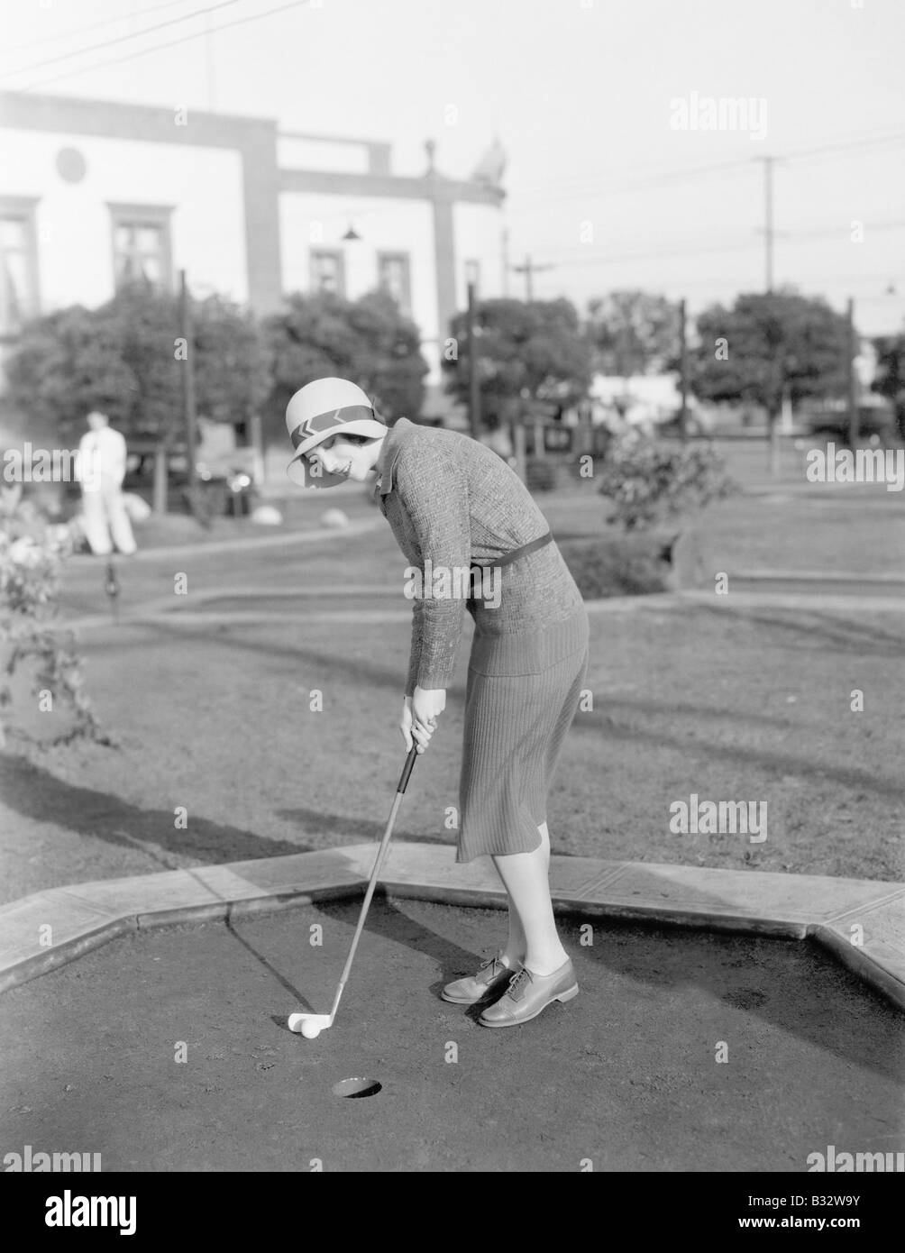 Young woman playing mini golf Stock Photo - Alamy