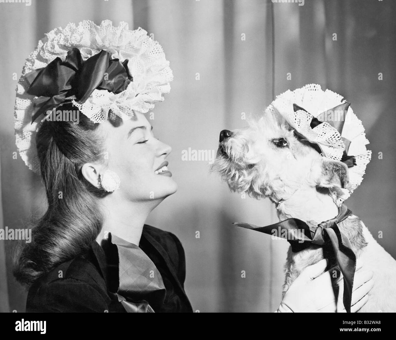 Young woman with her dog who is wearing the same hat Stock Photo - Alamy