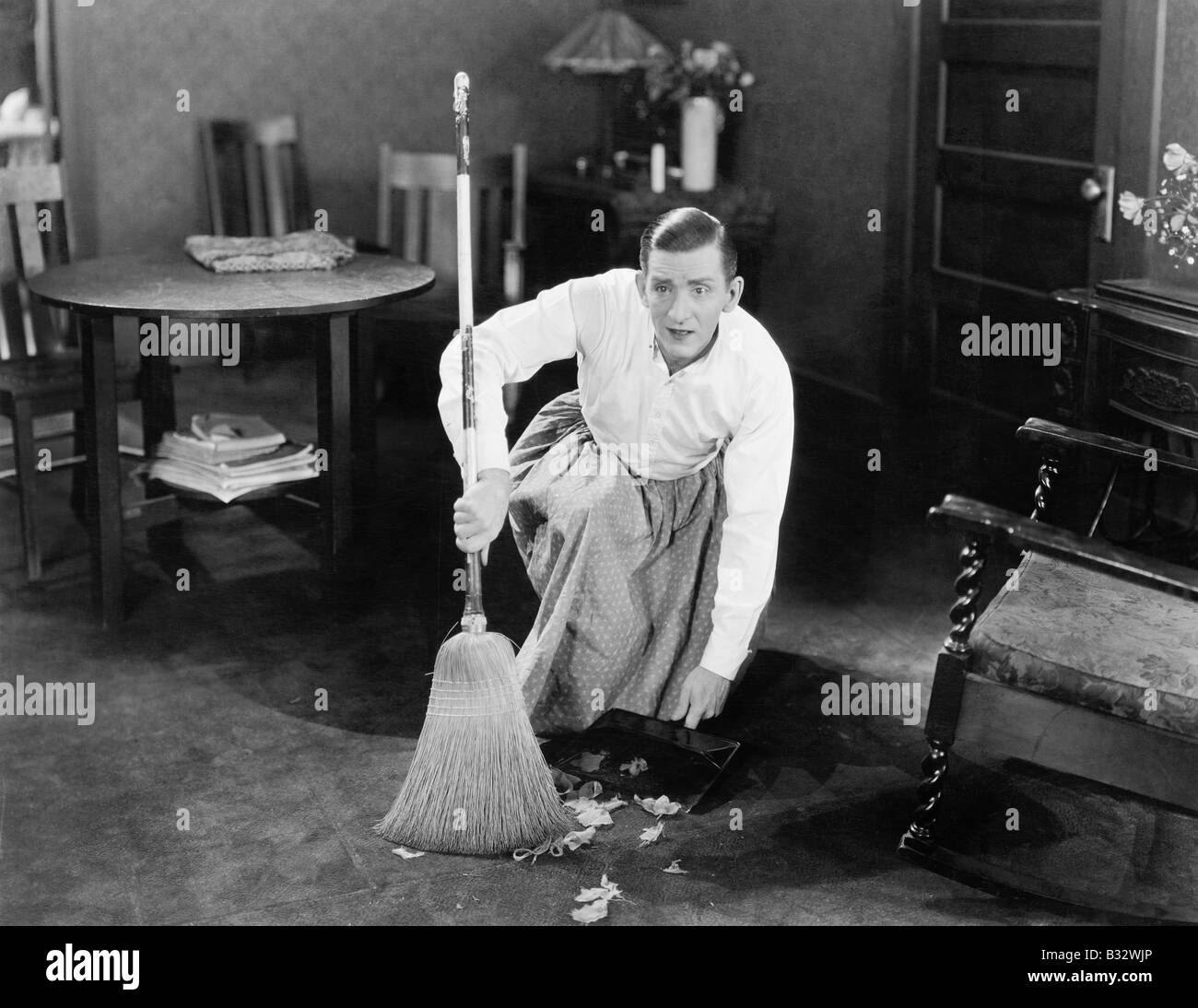 Man cleaning up with a broom Stock Photo - Alamy