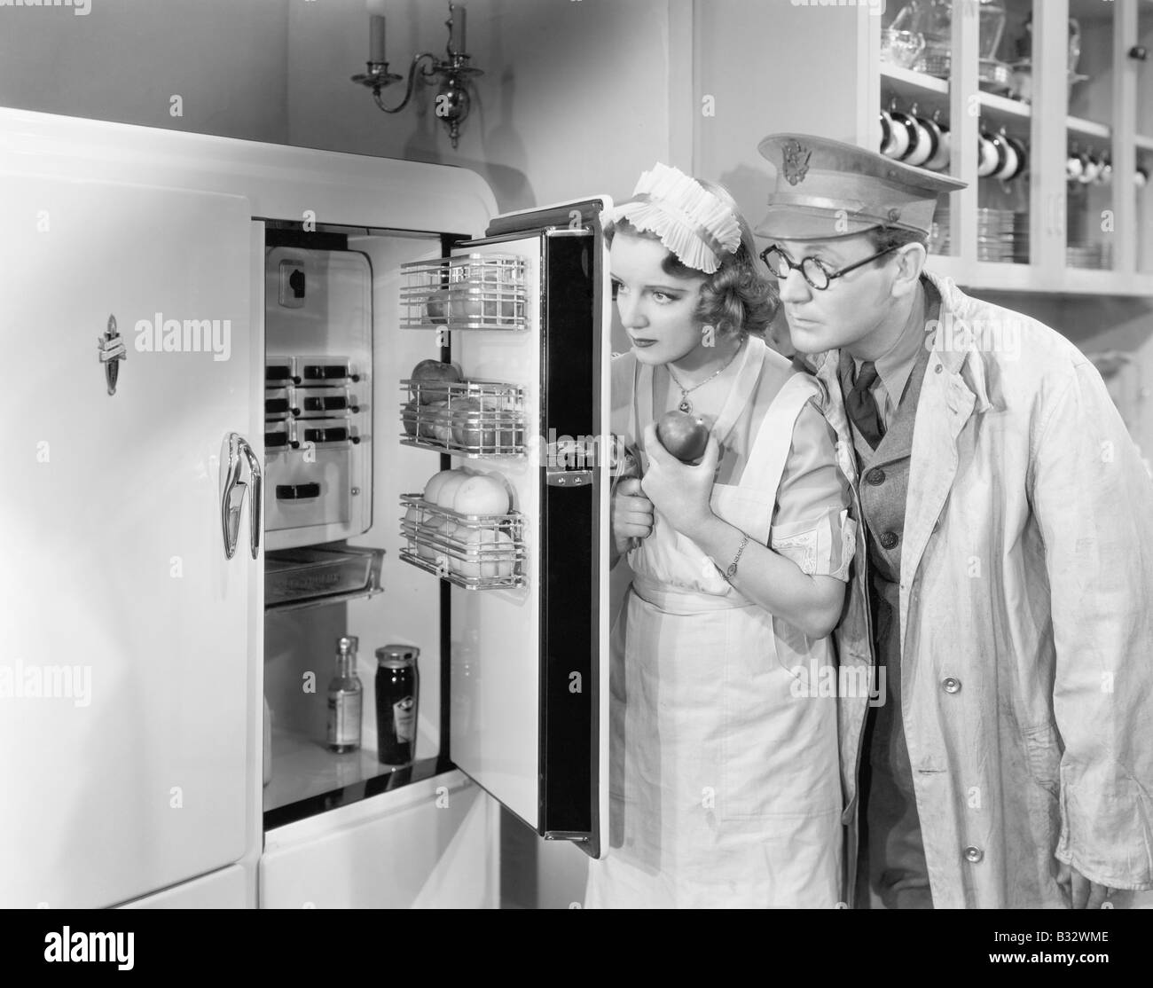Man and woman standing in front of a refrigerator Stock Photo - Alamy