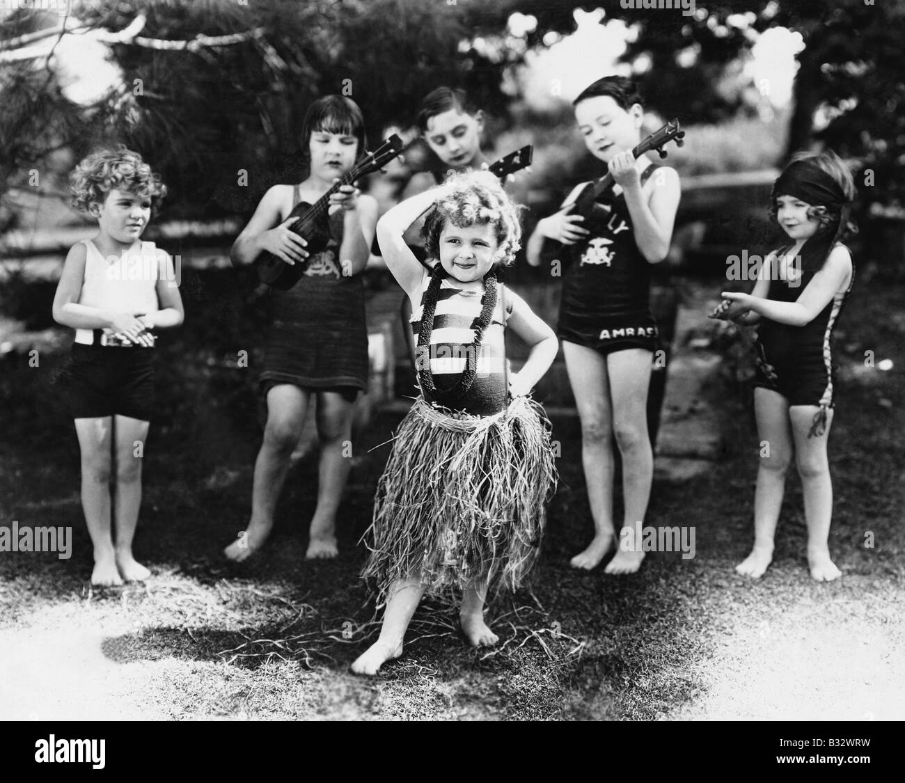 Group of children performing with instruments and one girl dancing the ...