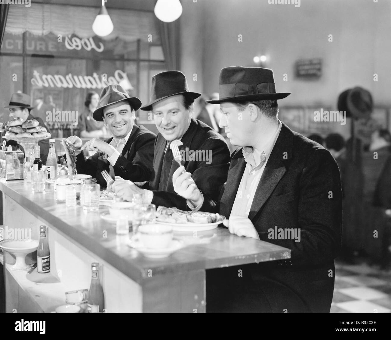 Three men sitting at the counter of a diner Stock Photo - Alamy
