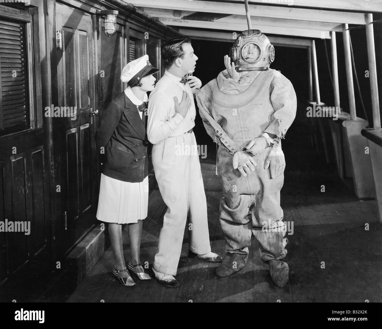 Two people looking in shock at a diver in a divers suit Stock Photo - Alamy