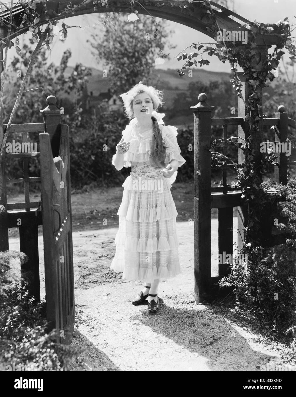 Young woman in a white dress, walking through an arch Stock Photo - Alamy