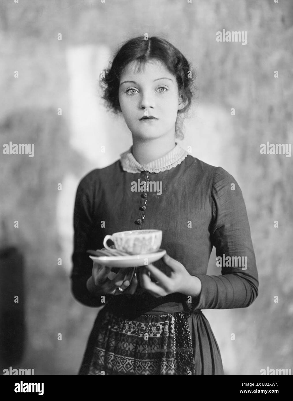 Woman standing with a cup of tea resting on her fingers Stock Photo - Alamy
