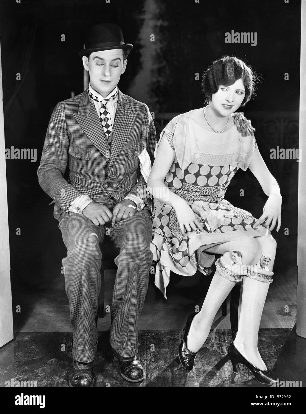 Man looking sheepishly down at the exposed knees of the young woman ...