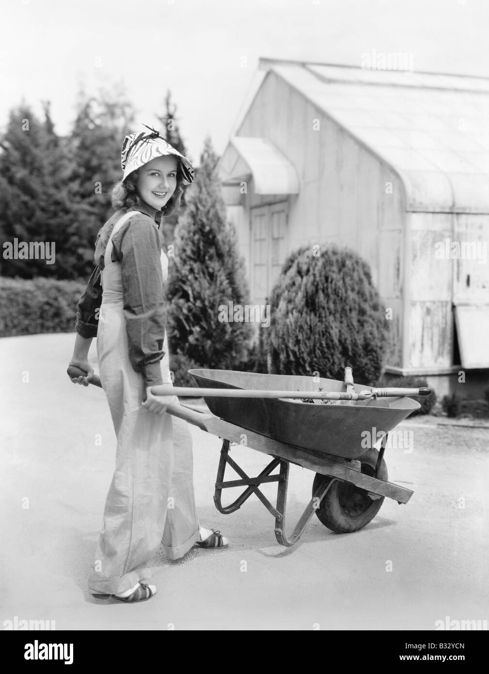 Woman walking with a wheel barrel Stock Photo - Alamy