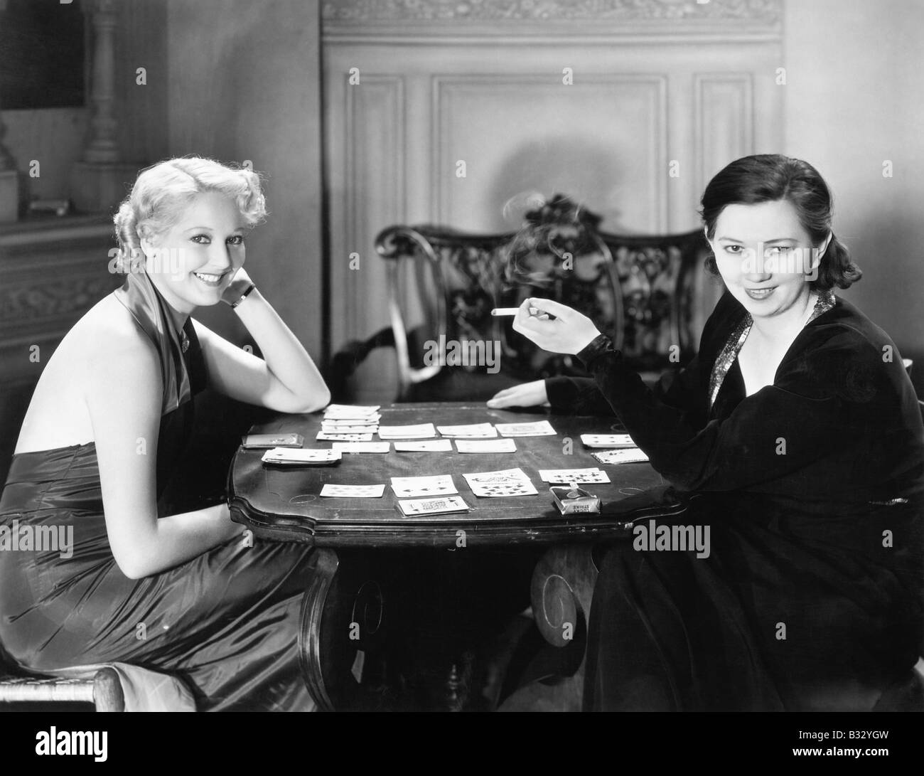 Two women sitting together playing cards Stock Photo - Alamy