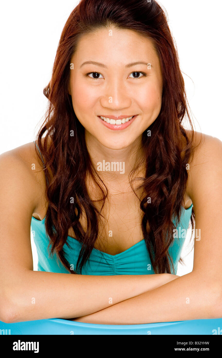 A pretty young asian woman resting arms on a chair Stock Photo - Alamy