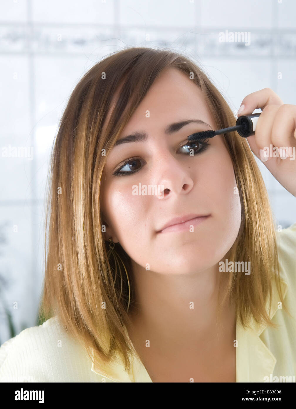 girl doing her make-up, applying mascara Stock Photo - Alamy