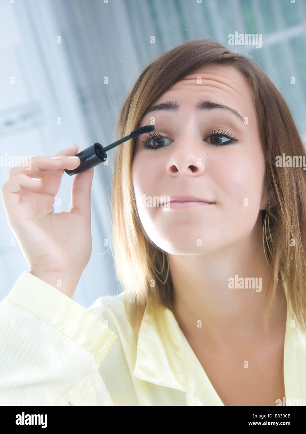 girl doing her make-up, applying mascara Stock Photo - Alamy