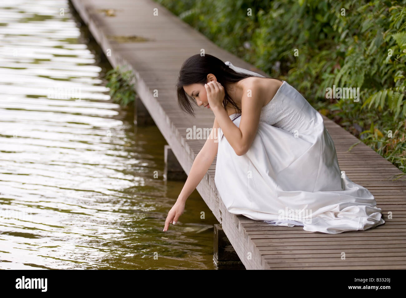 A bride looks hopefully into the water to try and recover a lost ...