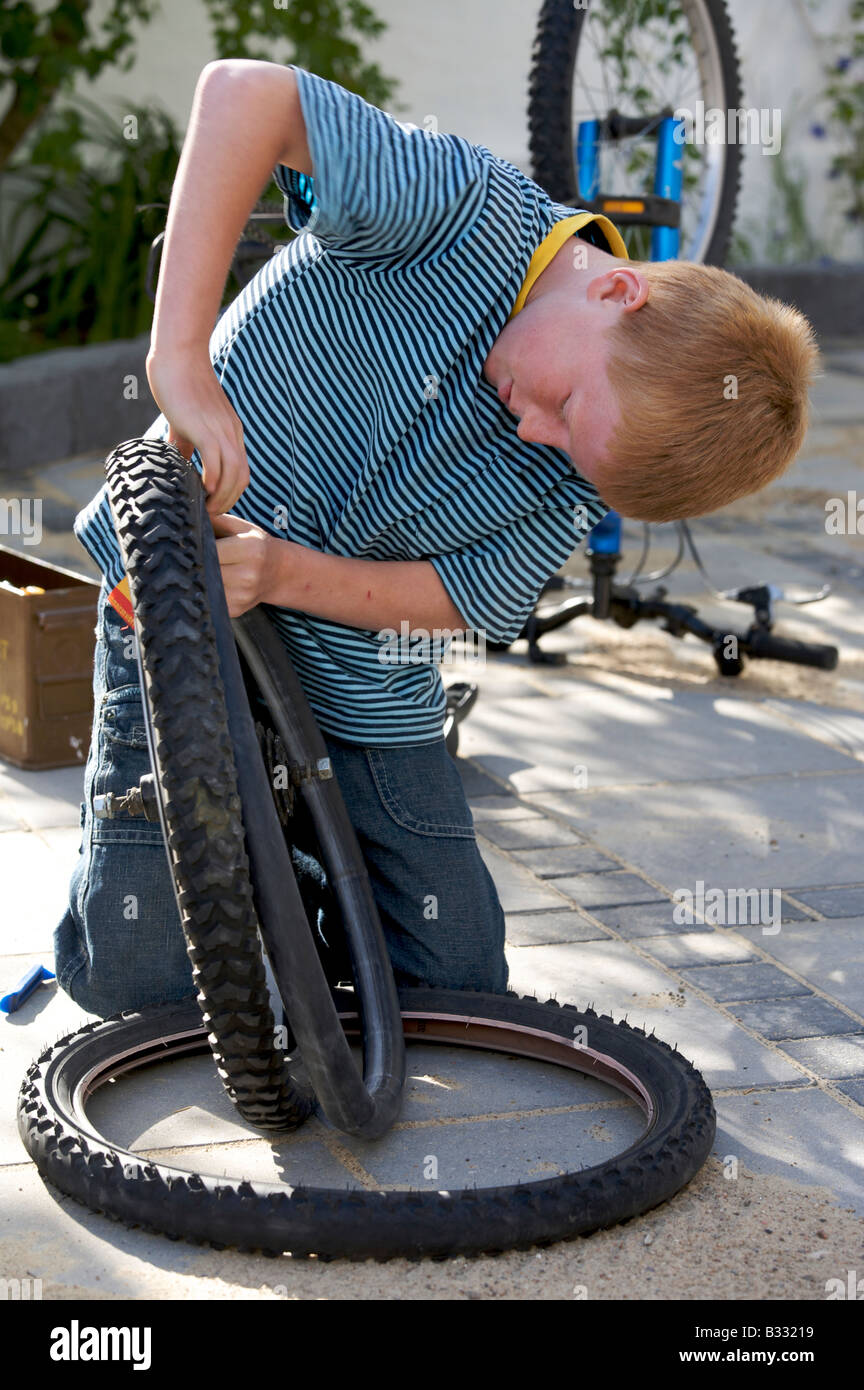 young white boy fixing puncture on his blue bike Stock Photo - Alamy