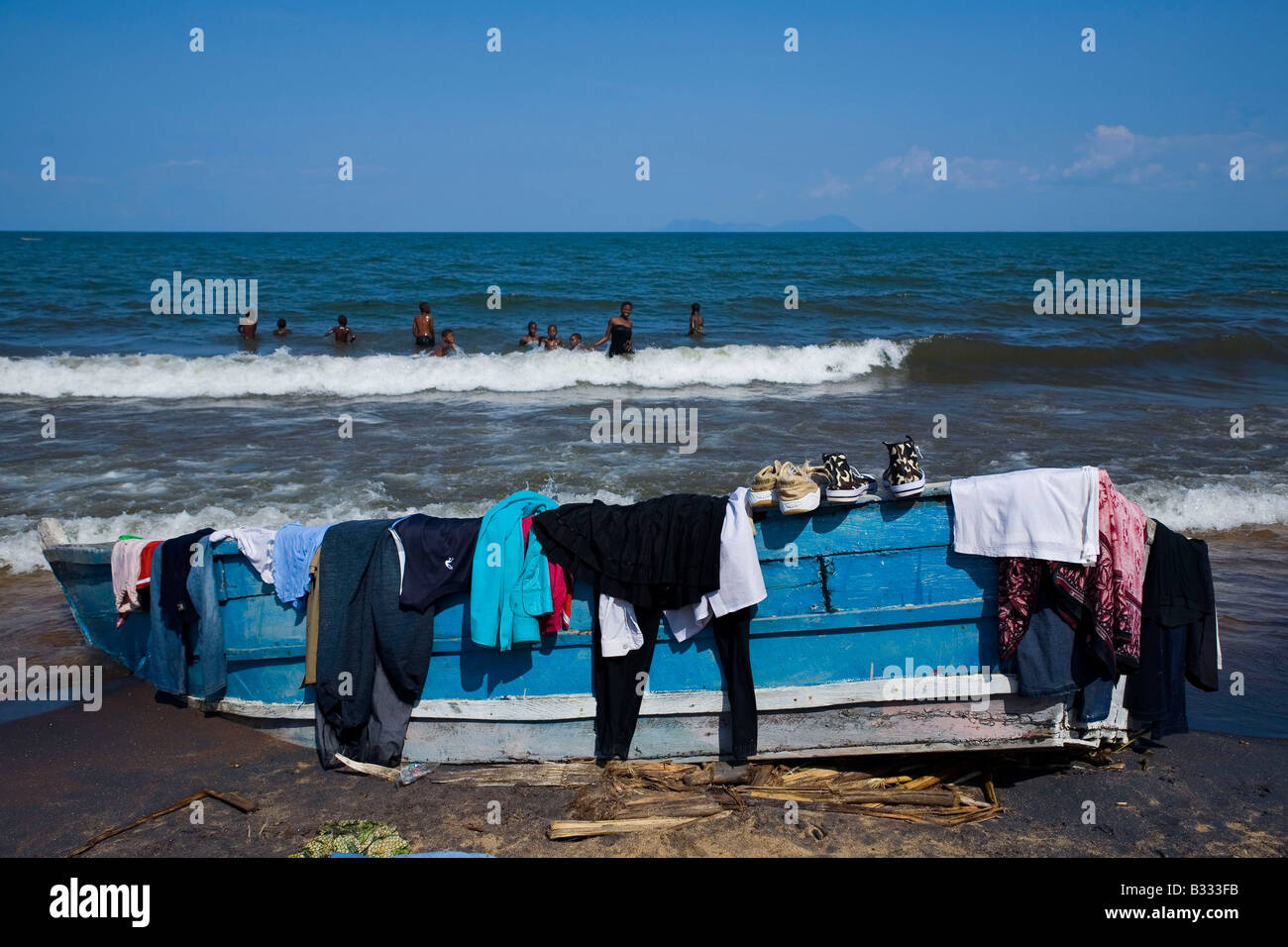 Clothes left on fishing boat whilst young people bath in the huge fresh ...