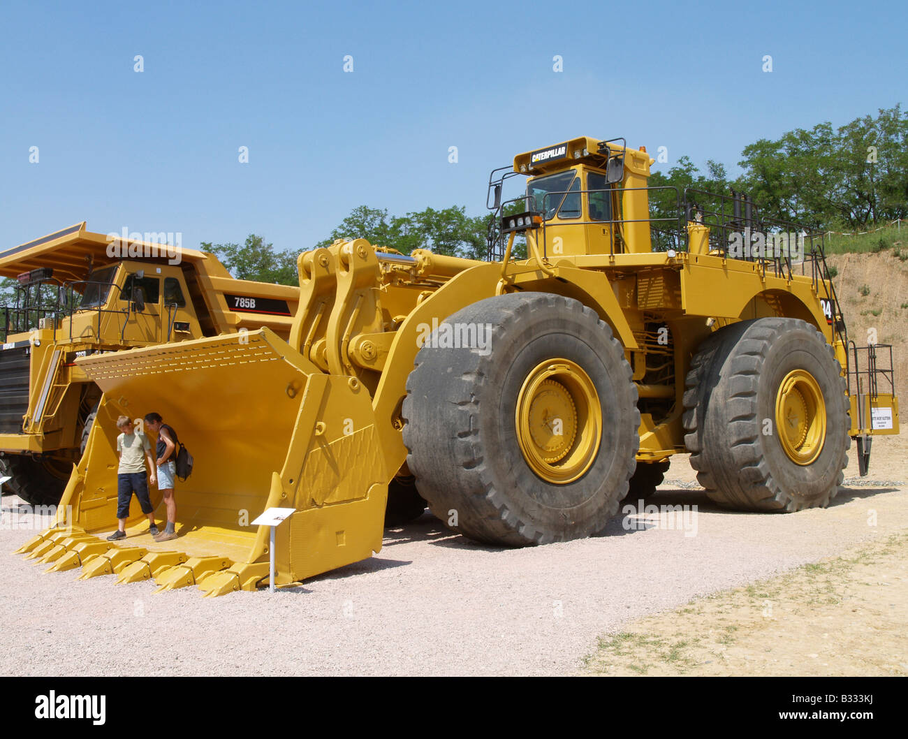 persons standing in the big excavator shovel of an excavator for ...