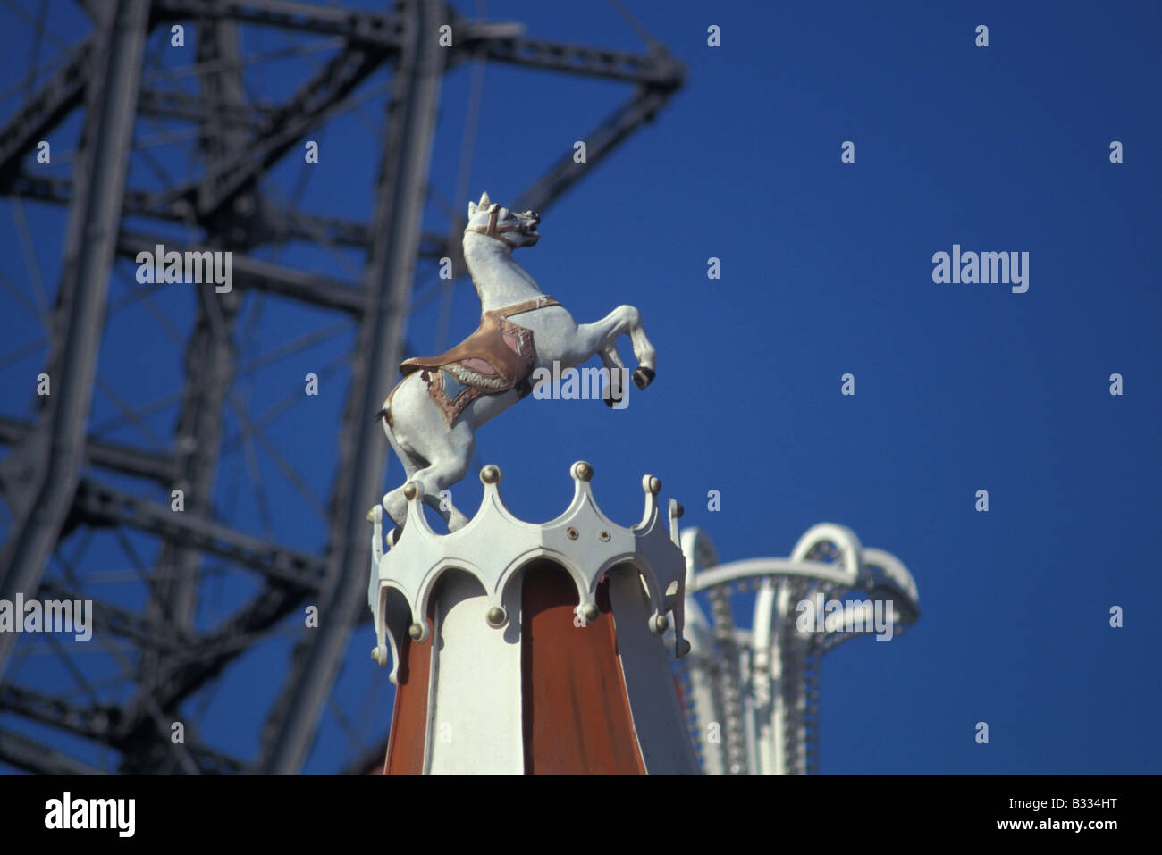 Horse roundabout detail with ferris wheel in the Wurstelprater Stock ...