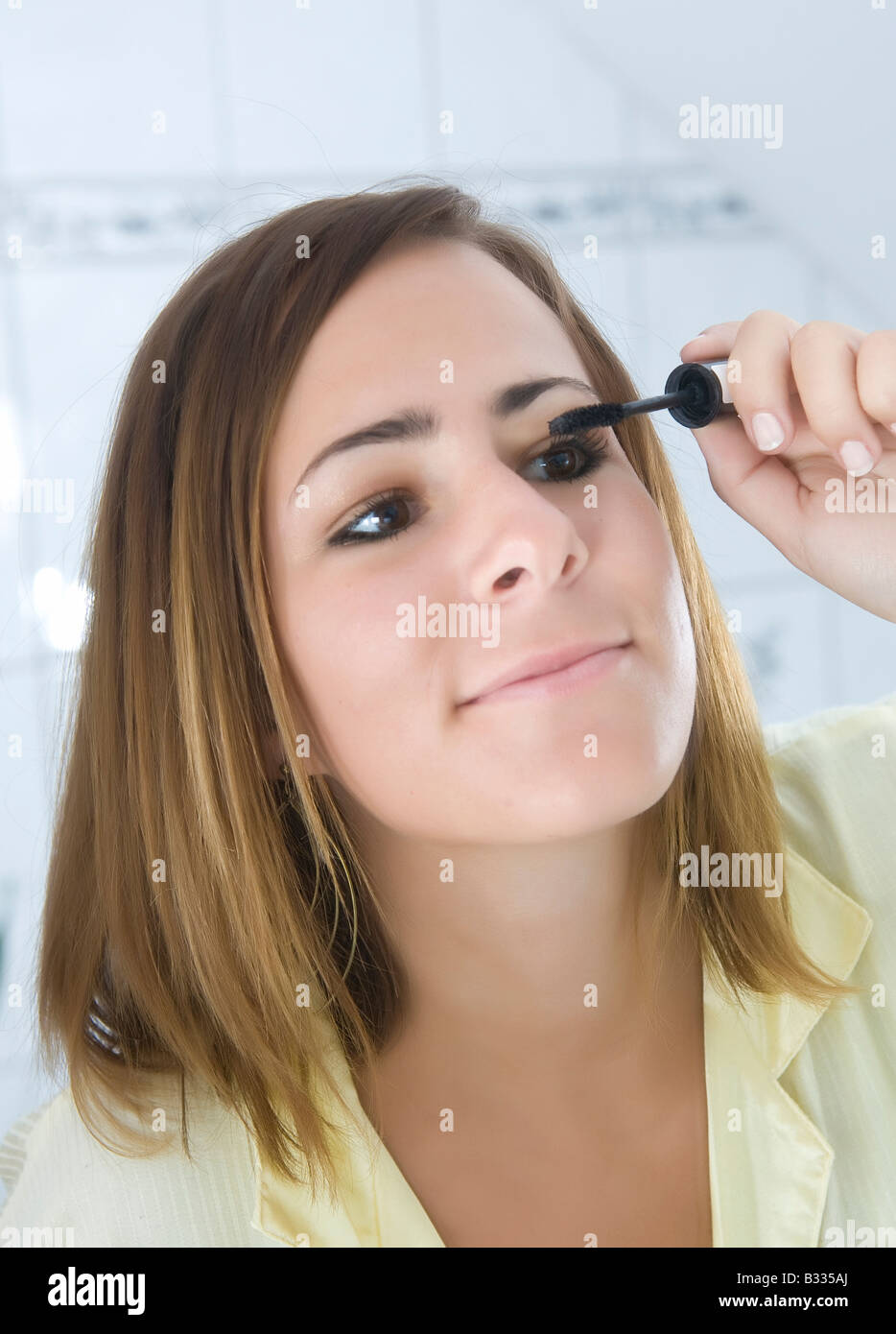 girl doing her make-up, applying mascara Stock Photo - Alamy