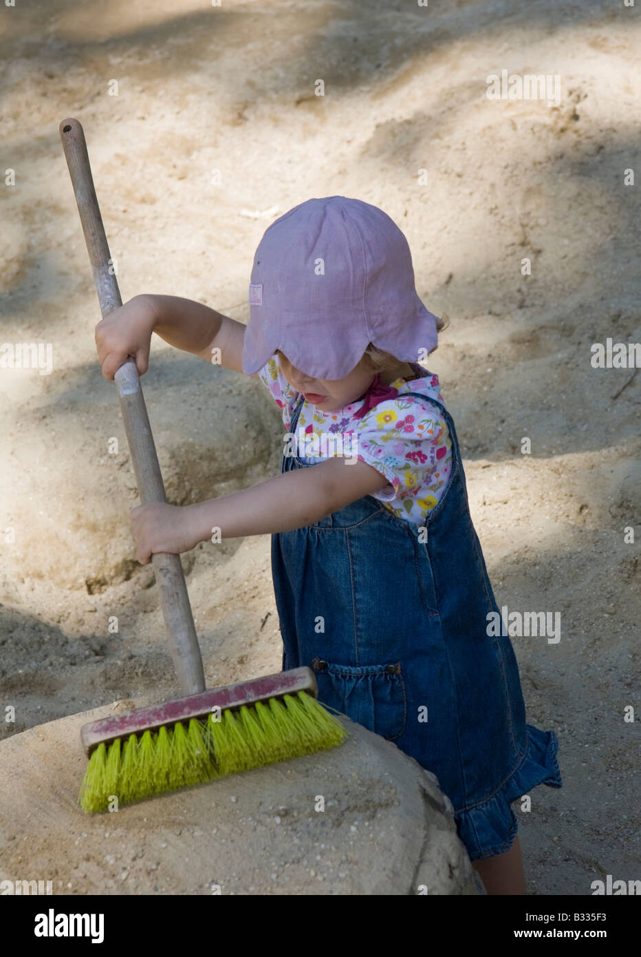 little girl playing with broom Stock Photo - Alamy