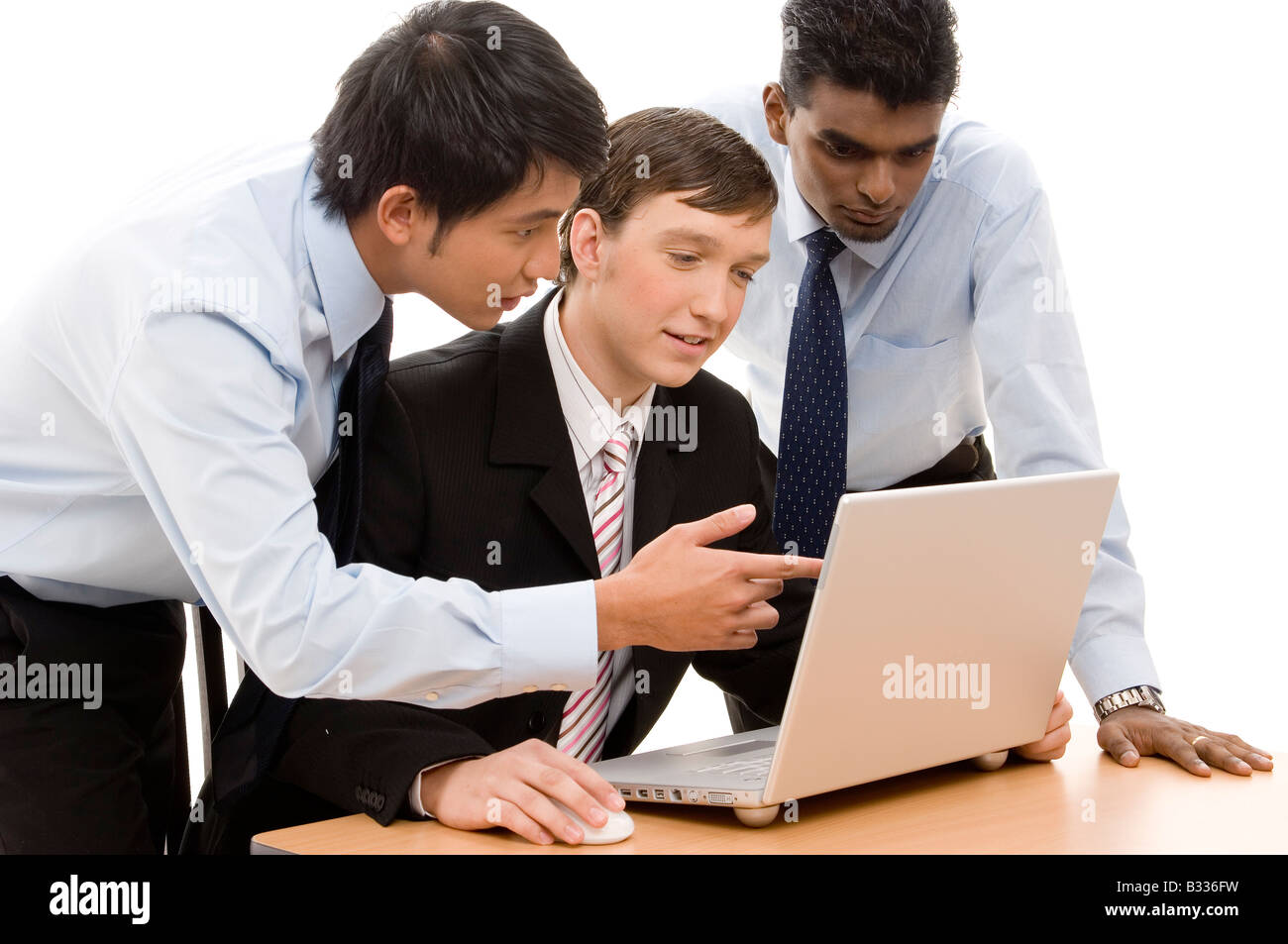 A group of three diverse businessmen look at a project on a laptop ...