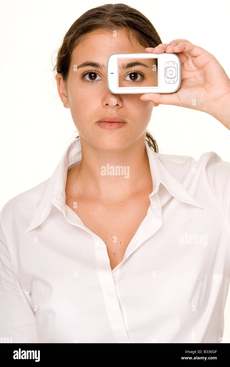 A young woman holds a smartphone to her face and the picture on the ...