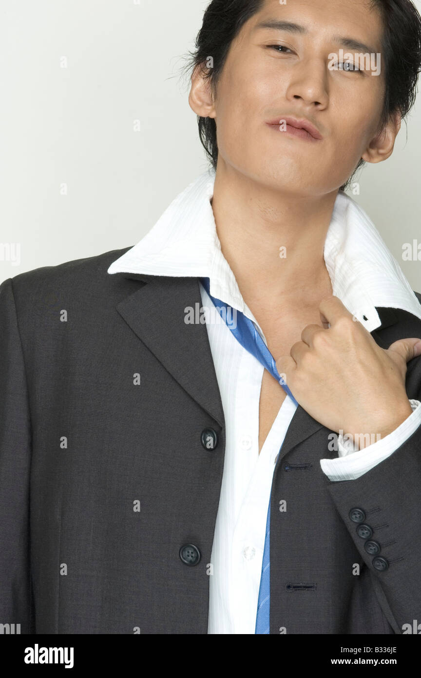 An asian businessman with collar undone and tie loose Stock Photo - Alamy