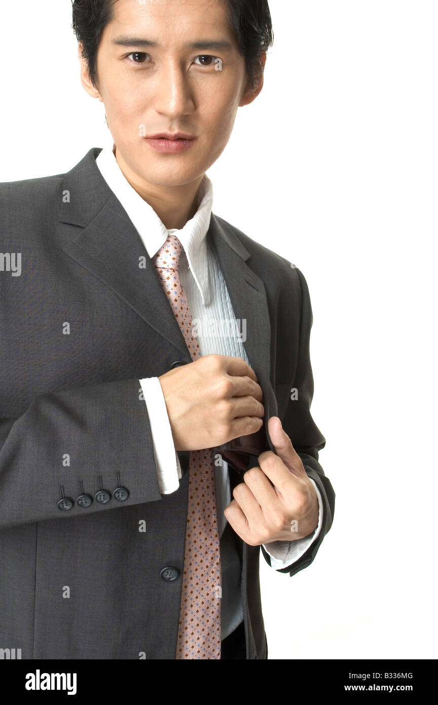 a businessman produces his wallet from his grey suit jacket pocket ...