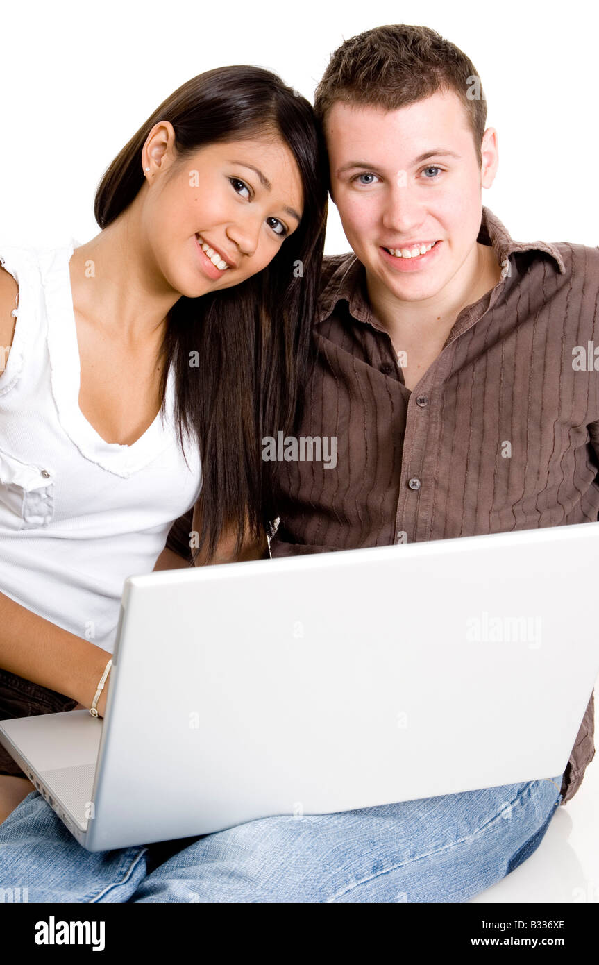 A young couple sitting with a laptop computer Stock Photo - Alamy