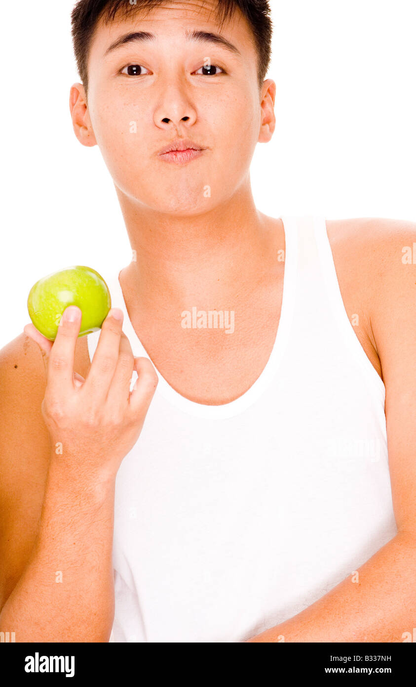 A asian man makes a strange face whilst holding an apple Stock Photo ...