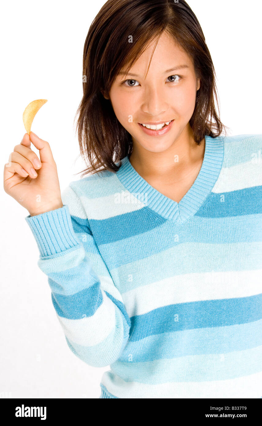 A pretty young asian woman holding up a chip Stock Photo - Alamy