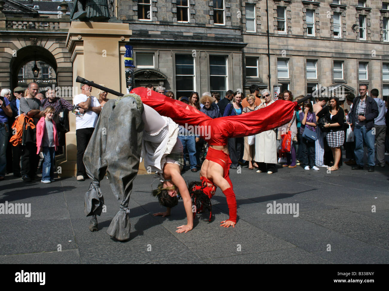 two women wearing stilts performing acrobatics promoting their show at ...