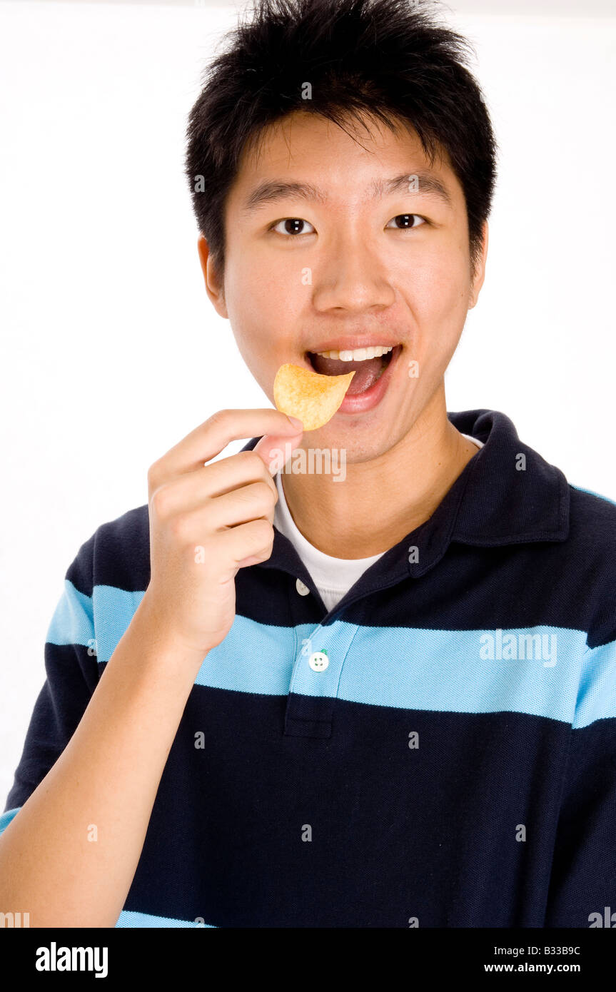 A young asian man eating potato chips Stock Photo - Alamy