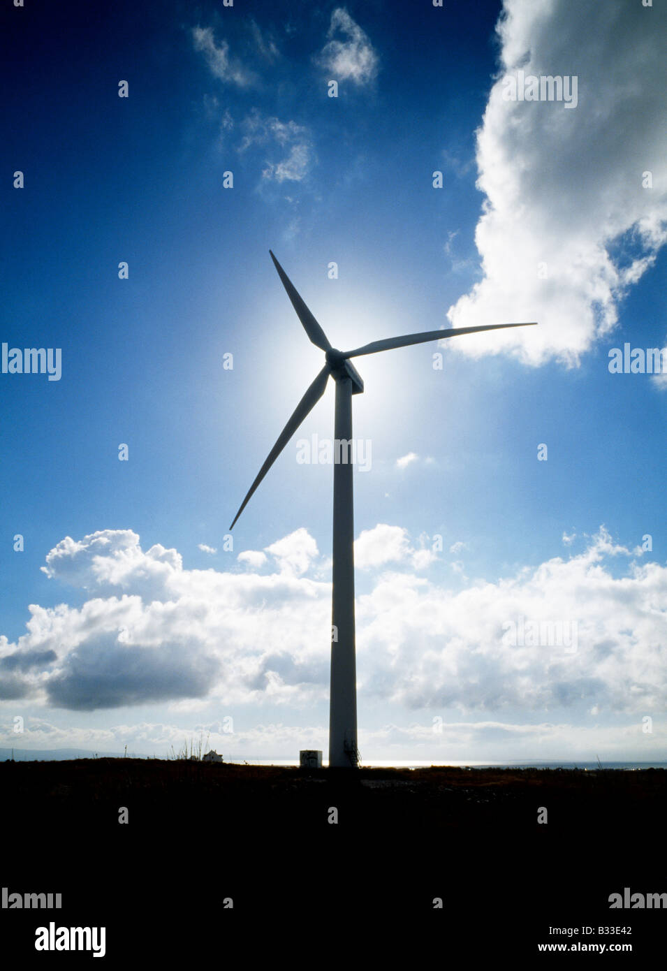 A wind turbine under a sky with billowing clouds Stock Photo - Alamy