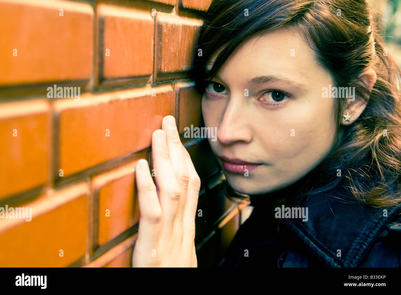 Beautiful girl waiting against brick wall Stock Photo - Alamy