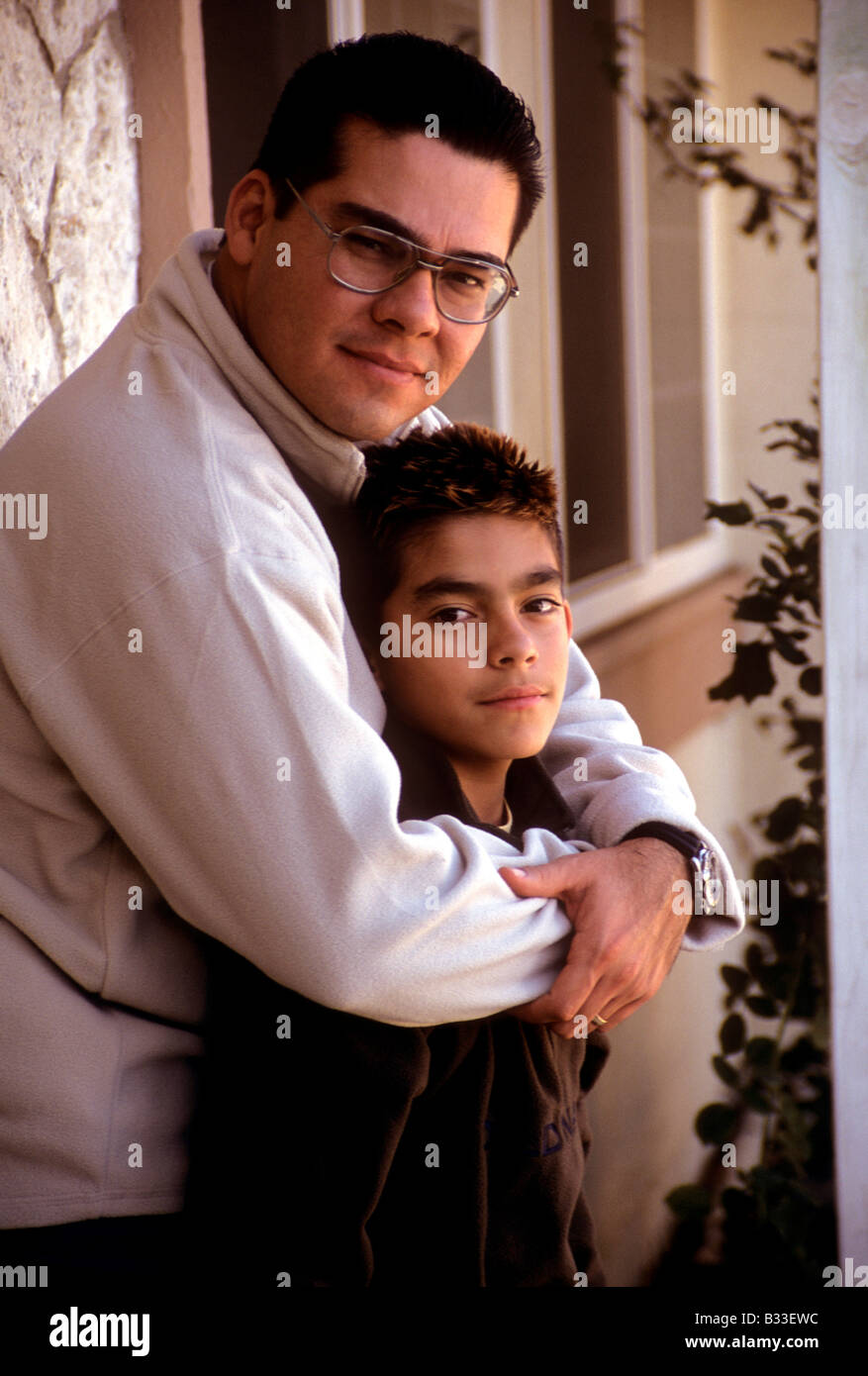 Hispanic father hugs son in outdoor portrait Stock Photo - Alamy