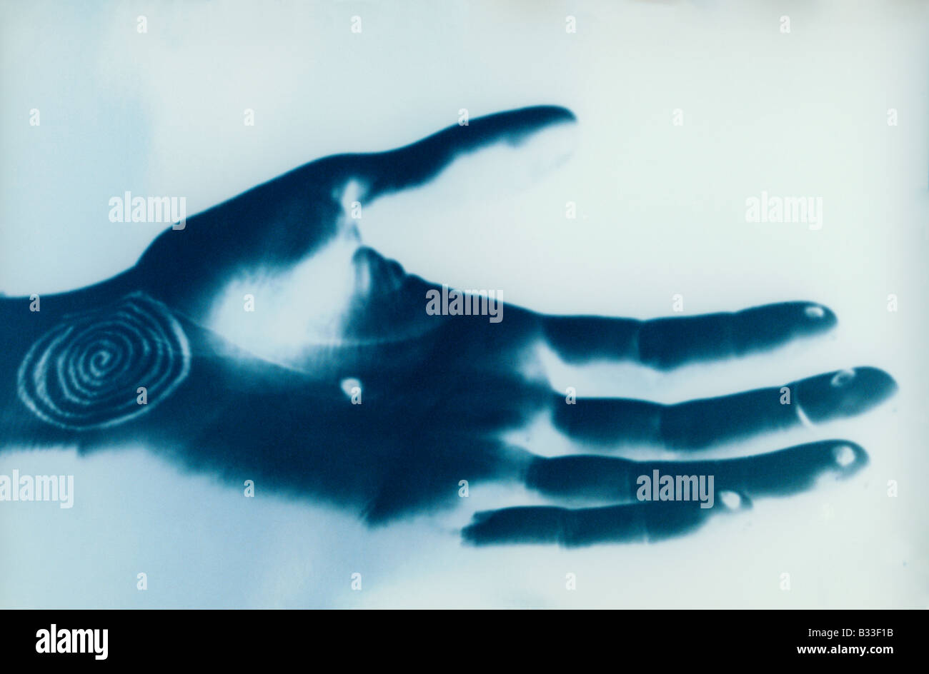 Ghostly blue ethereal hand with mysterious spiral and dot tatoos open ...