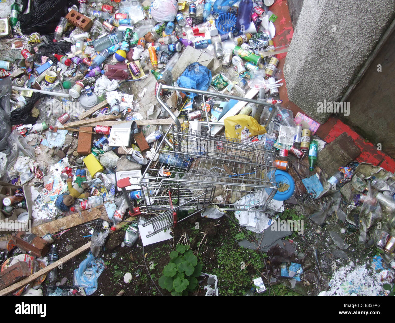 litter and shopping trolley dumped in back alley Stock Photo - Alamy
