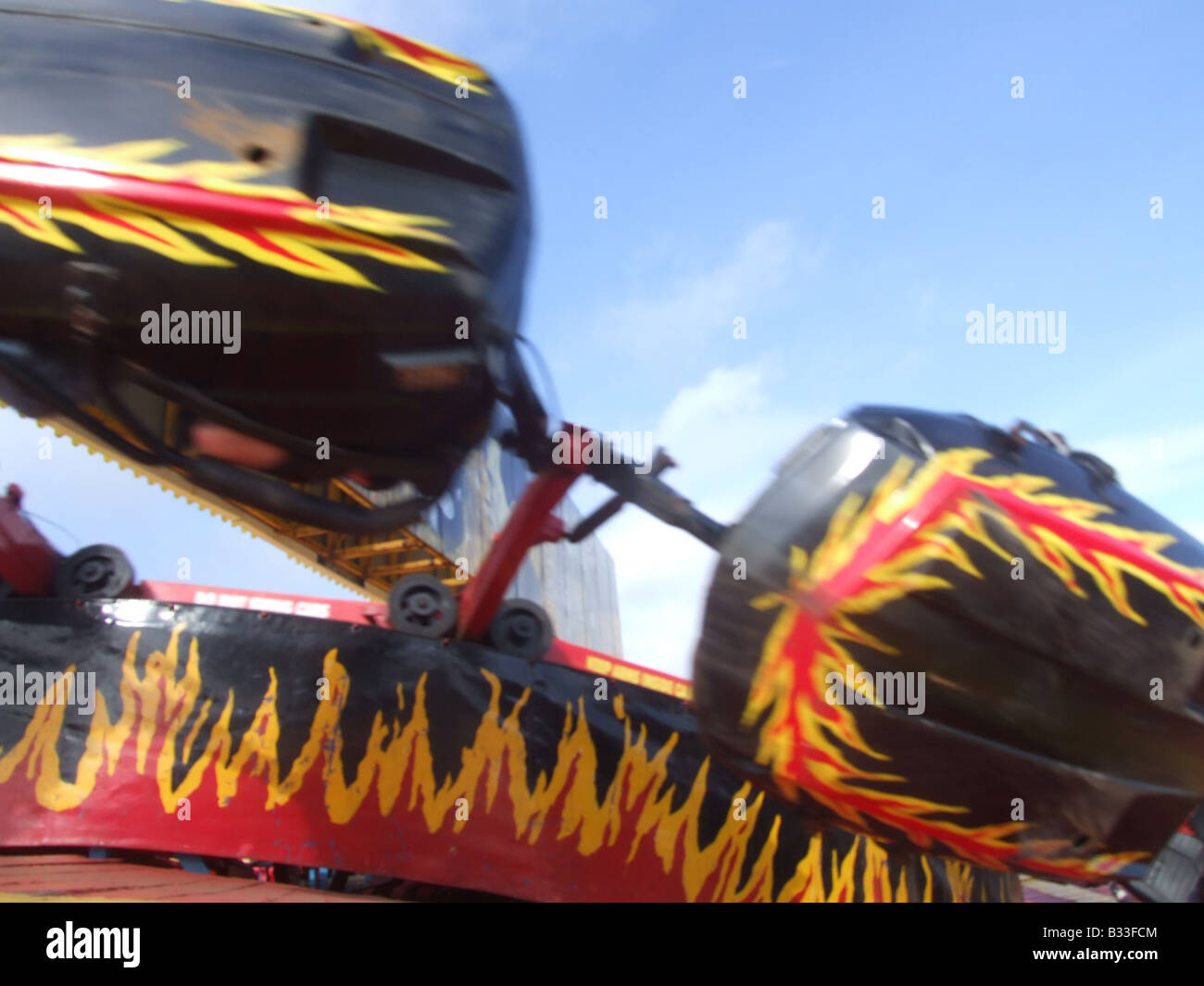 fair ground ride cars moving fast in sun Stock Photo - Alamy