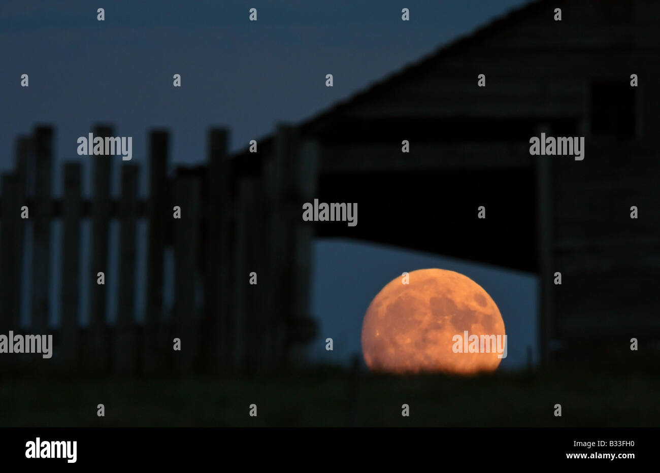 Full moon seen through old building window Stock Photo - Alamy