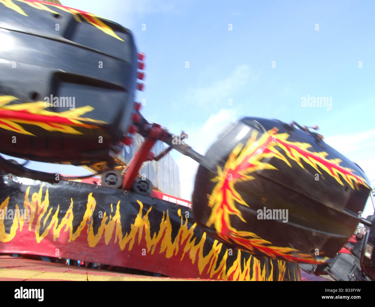 fair ground ride cars moving fast in sun Stock Photo - Alamy