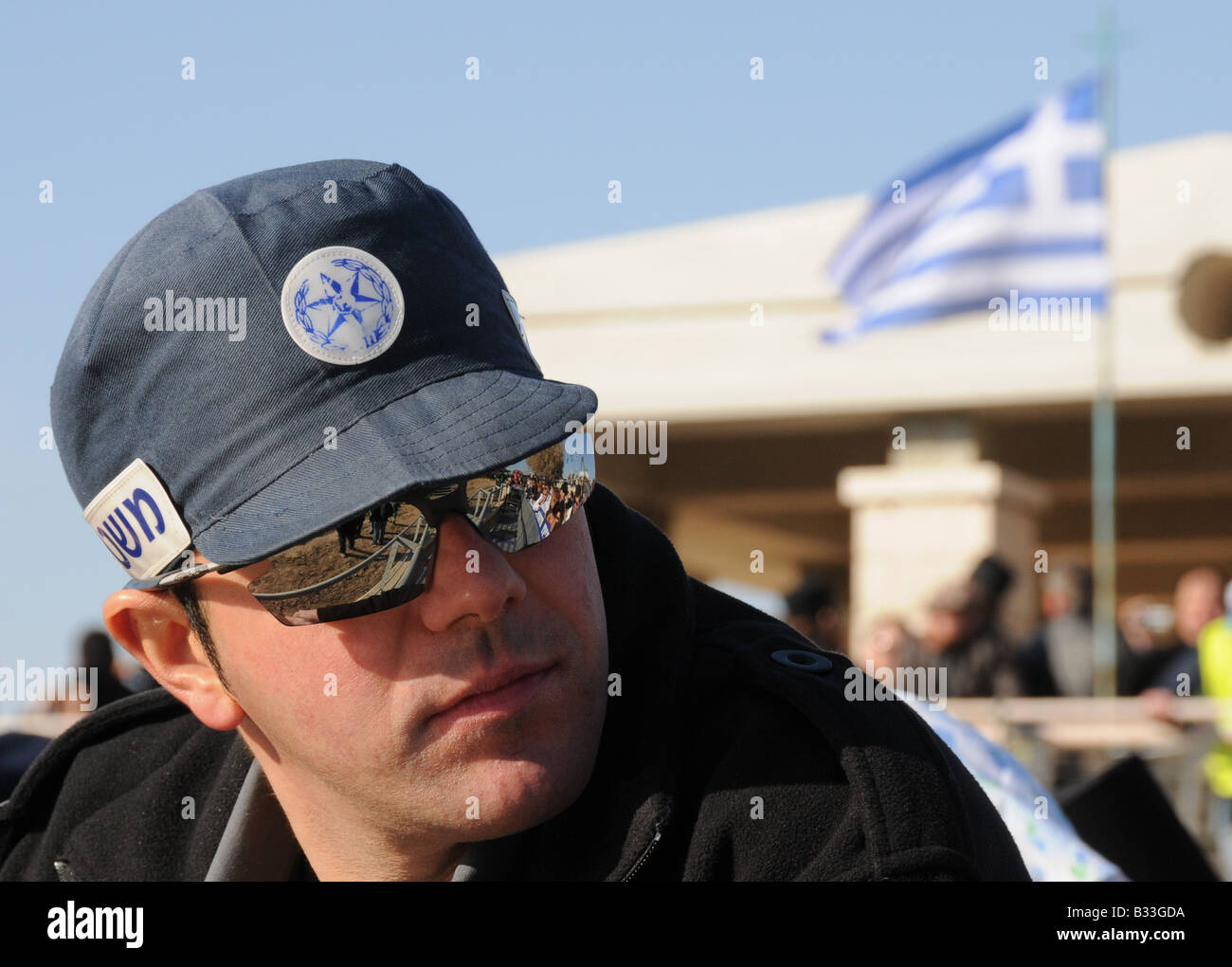 An Israeli policeman watches an annual Greek Orthodox mass-Baptism on ...