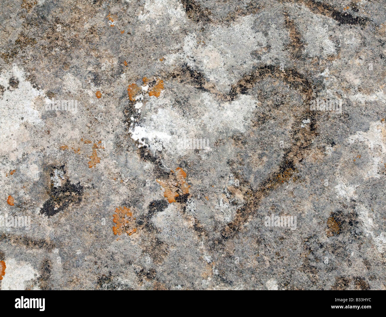 one old heart carved into stone wall in sun Stock Photo - Alamy