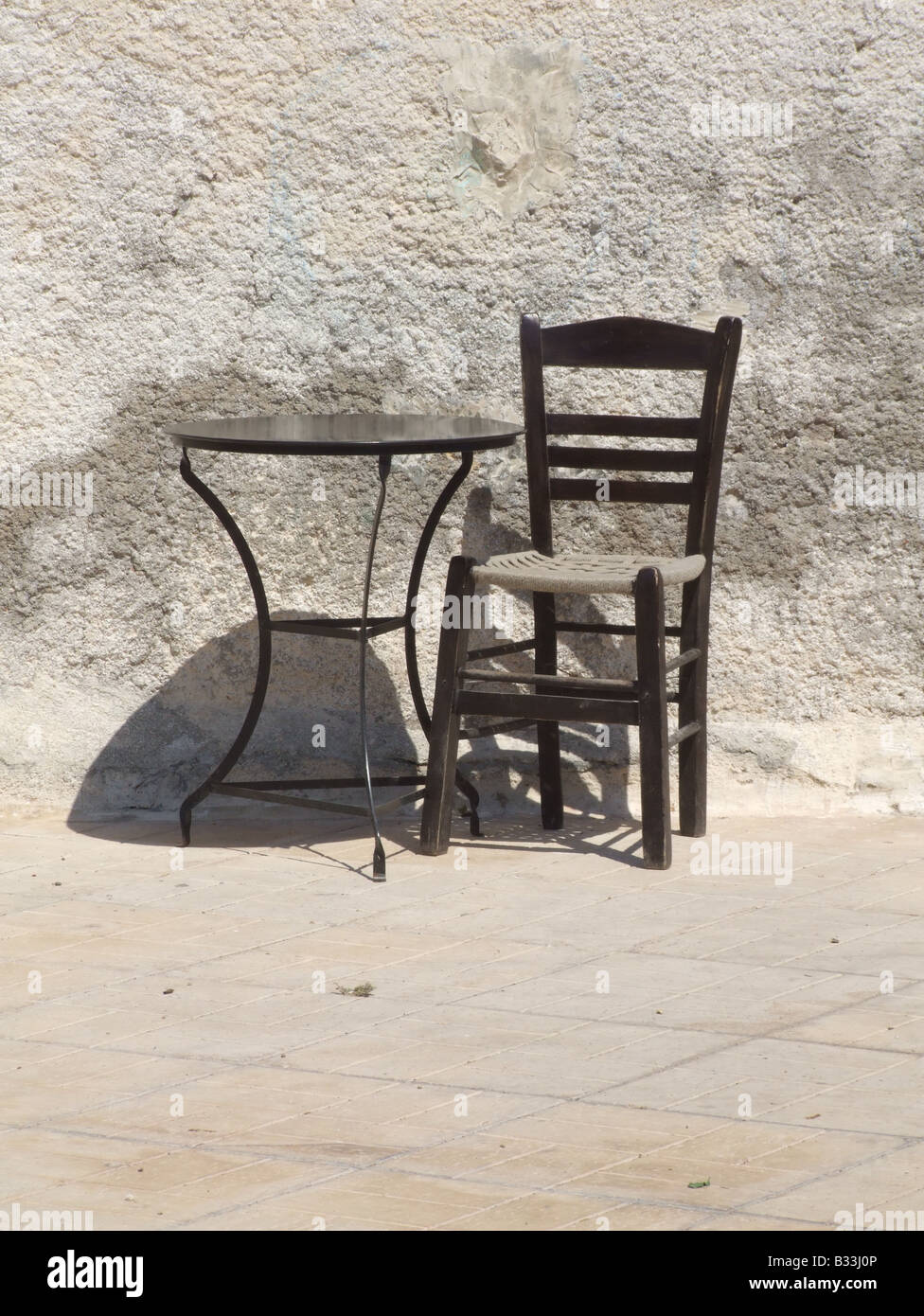 one empty table and chair in street in sun Stock Photo - Alamy