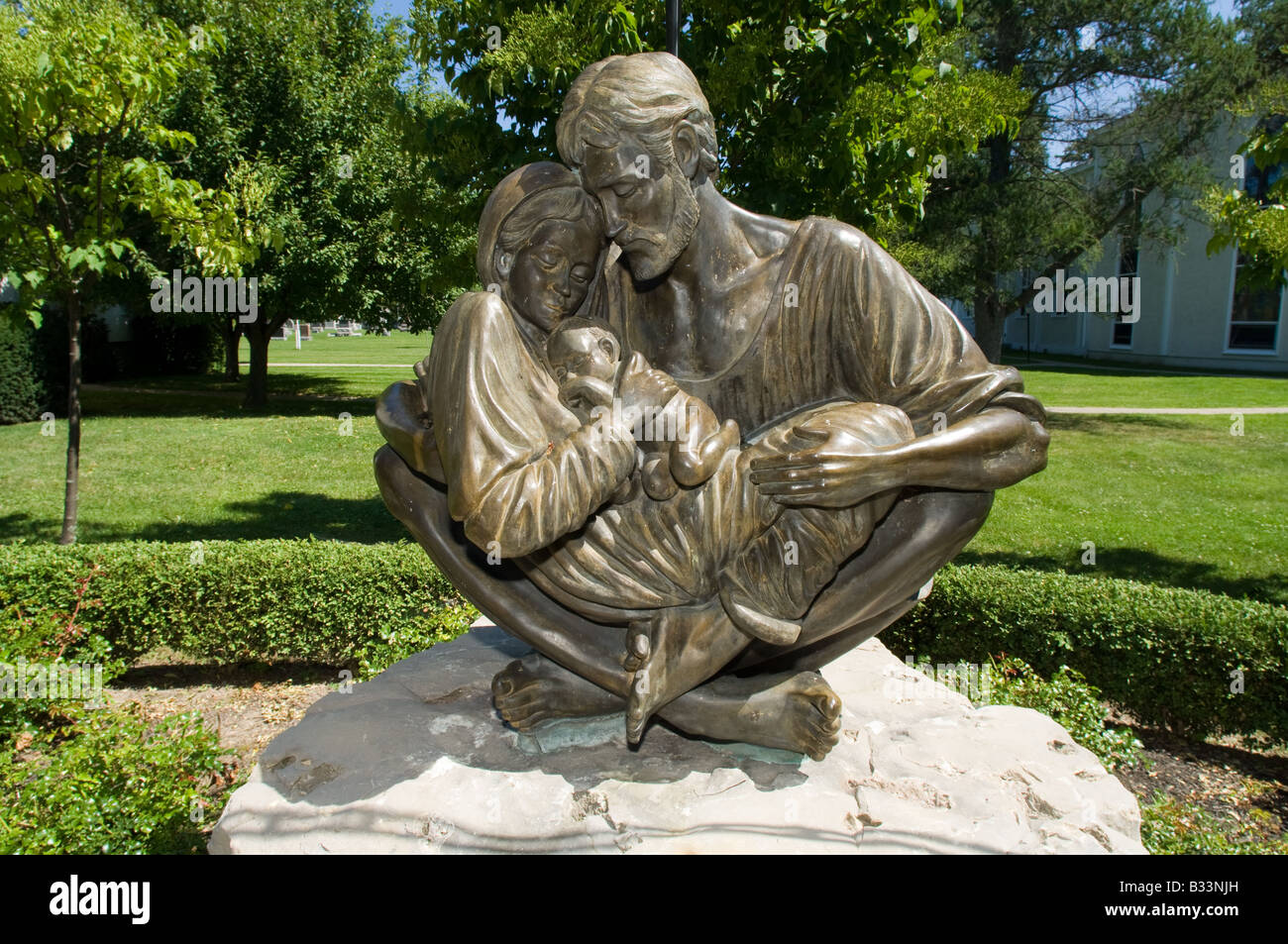 Statue of a man holding a woman holding a child Stock Photo - Alamy