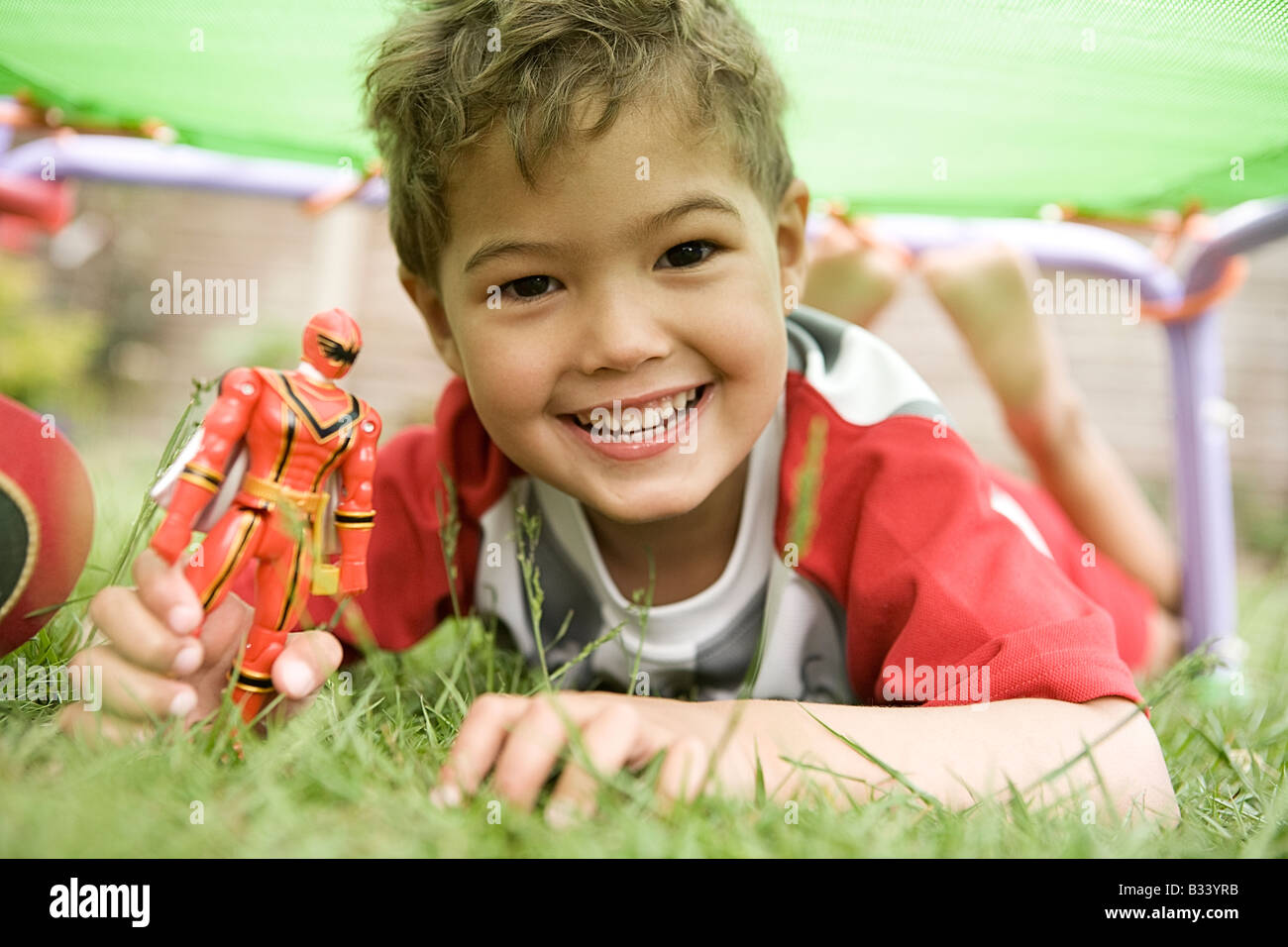 Boy plays with his Power Ranger in the Garden Stock Photo - Alamy